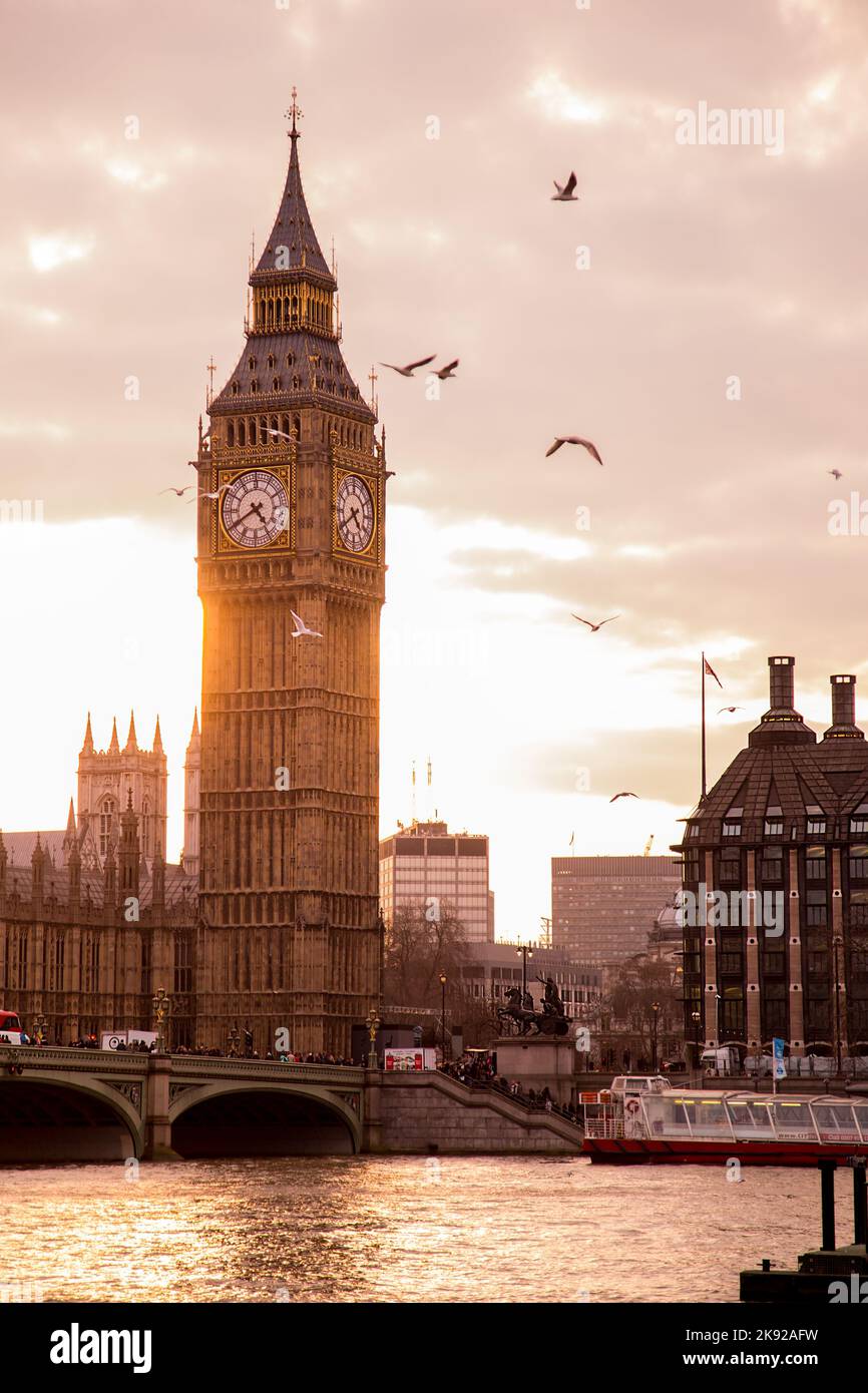 Yellow sunset behind the Big Ben building. Cloudy evening in London ...