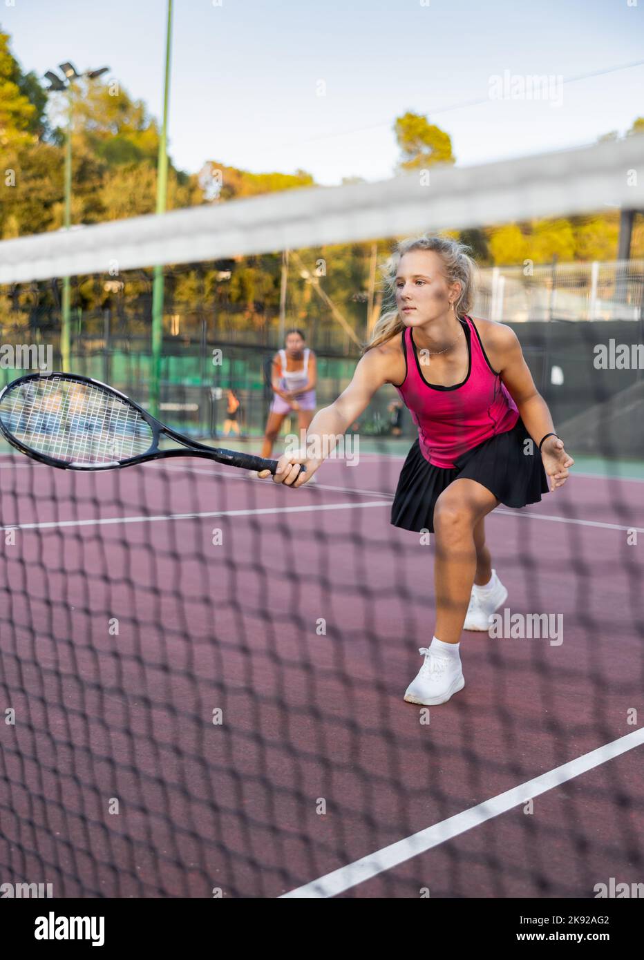 Female player playing tennis in tennis court outdoor behind net Stock ...