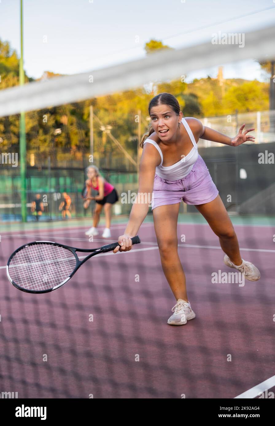 Female player playing tennis in tennis court outdoor behind net Stock ...