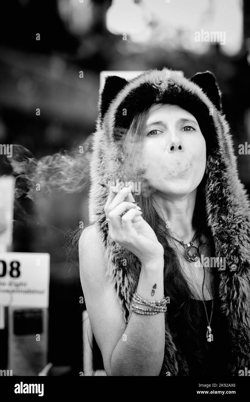 A young woman in a Halloween hat smokes a hemp flower (Cannabis sativa) joint, which is legal in ...