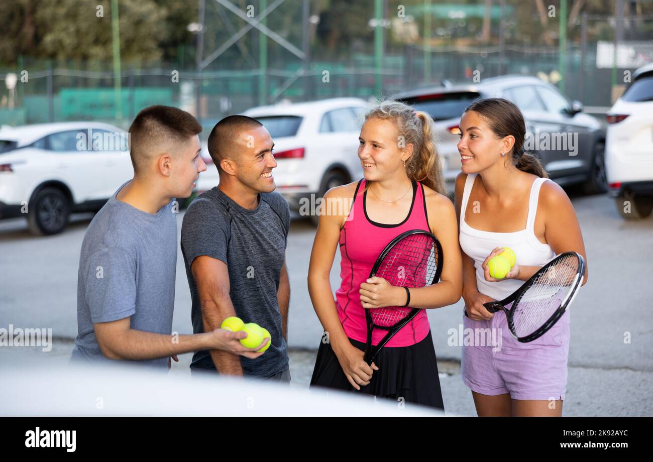 Positive tennis players talking on parking lot Stock Photo - Alamy