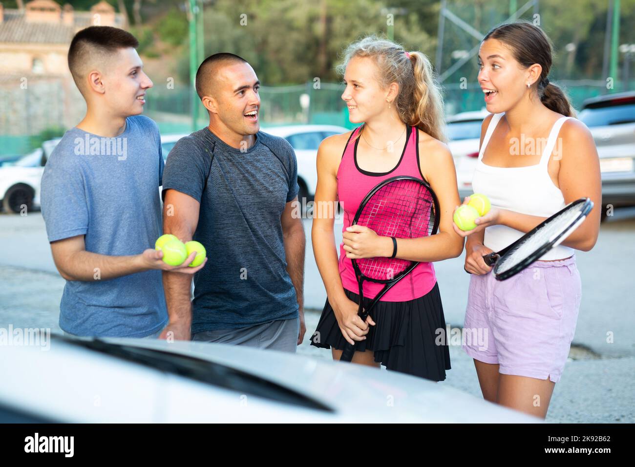 Positive tennis players talking on parking lot Stock Photo - Alamy