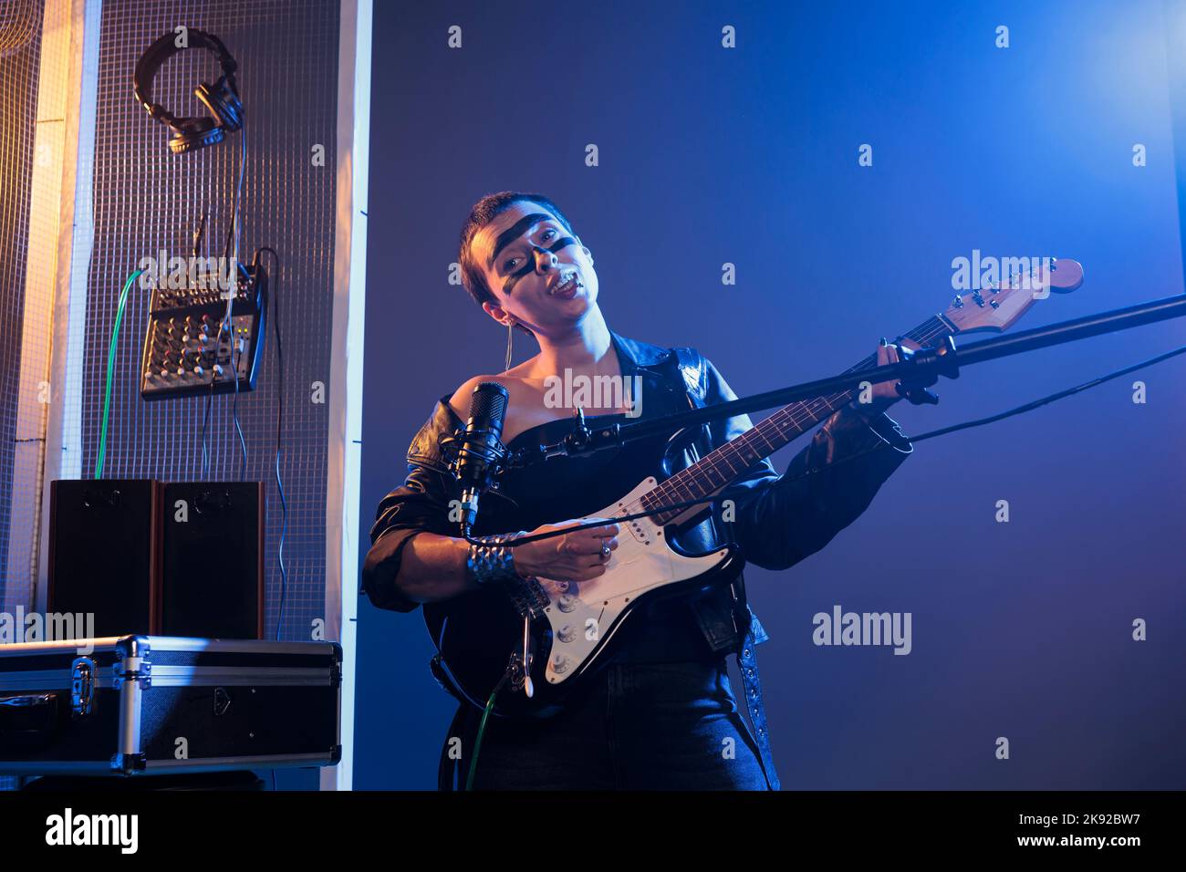 Stylish rocker doing live show singing heavy metal music with guitar ...