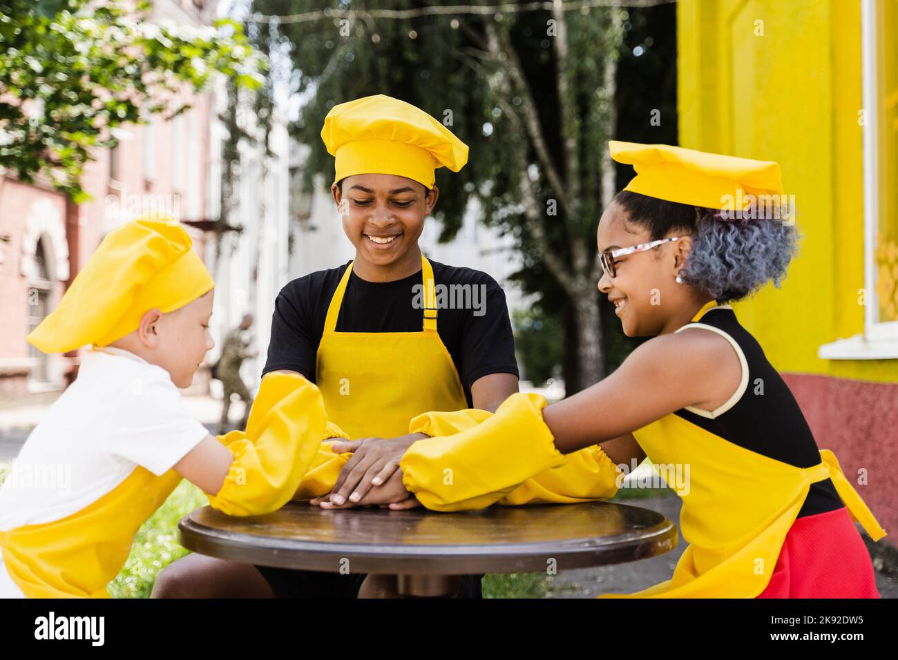 Teambuilding of multinational children cooks in chefs hat and yellow ...