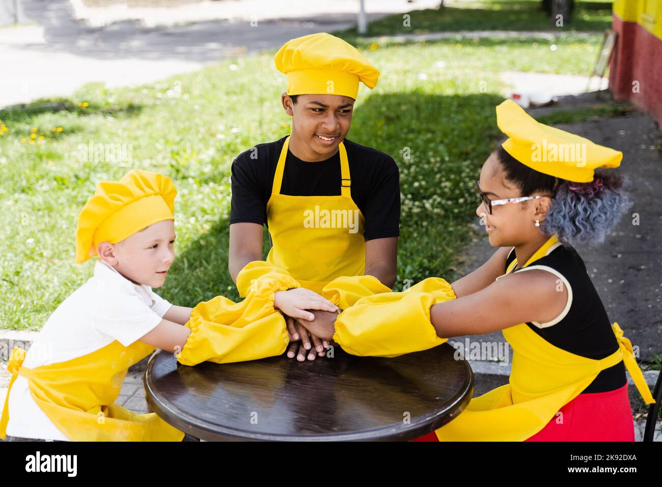 Multiracial children cook touching hands together forming pile ...