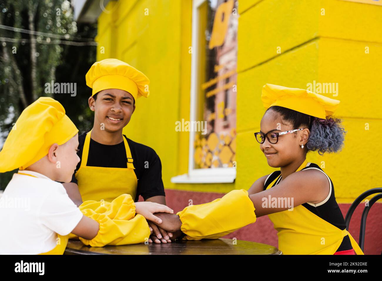 Multiracial children cook touching hands together forming pile ...