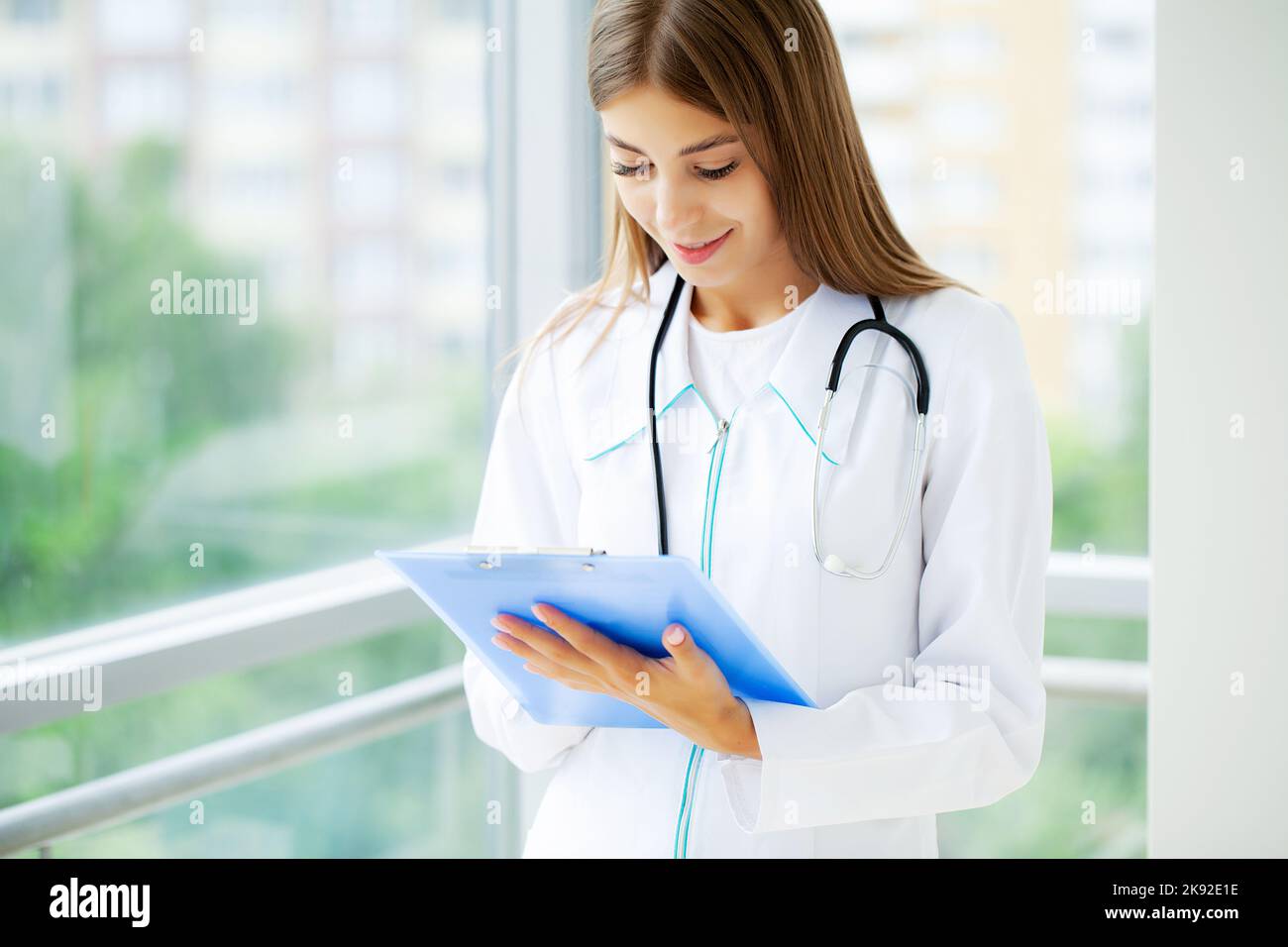 Female Doctor In Surgery Reading Patient Notes Stock Photo - Alamy