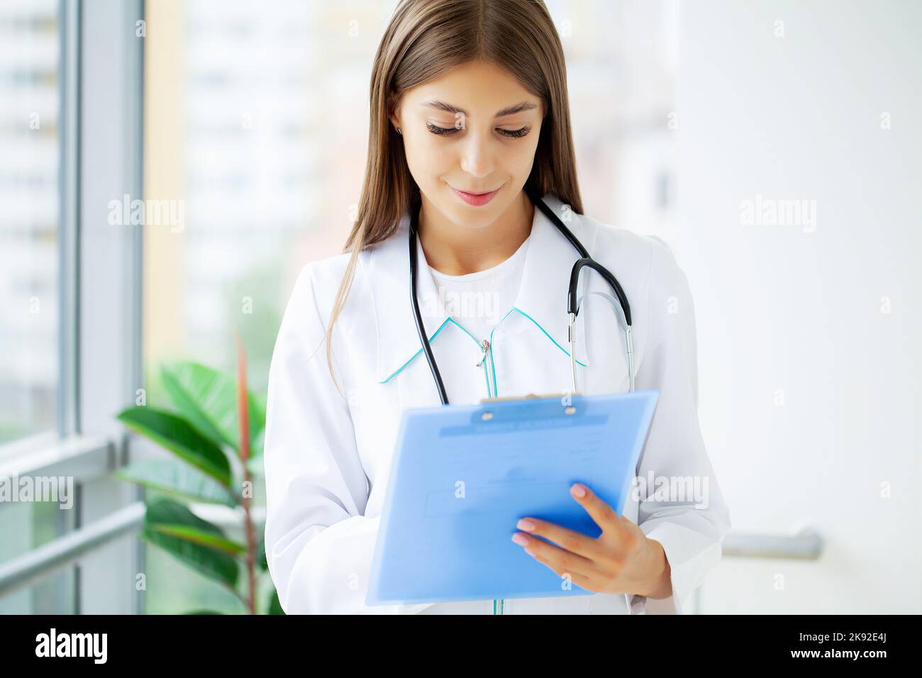Female Doctor In Surgery Reading Patient Notes Stock Photo - Alamy