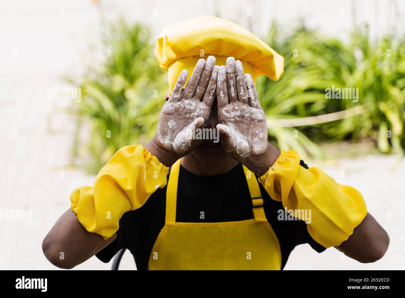 Black african cook teenager showing hands with flour and close his face ...