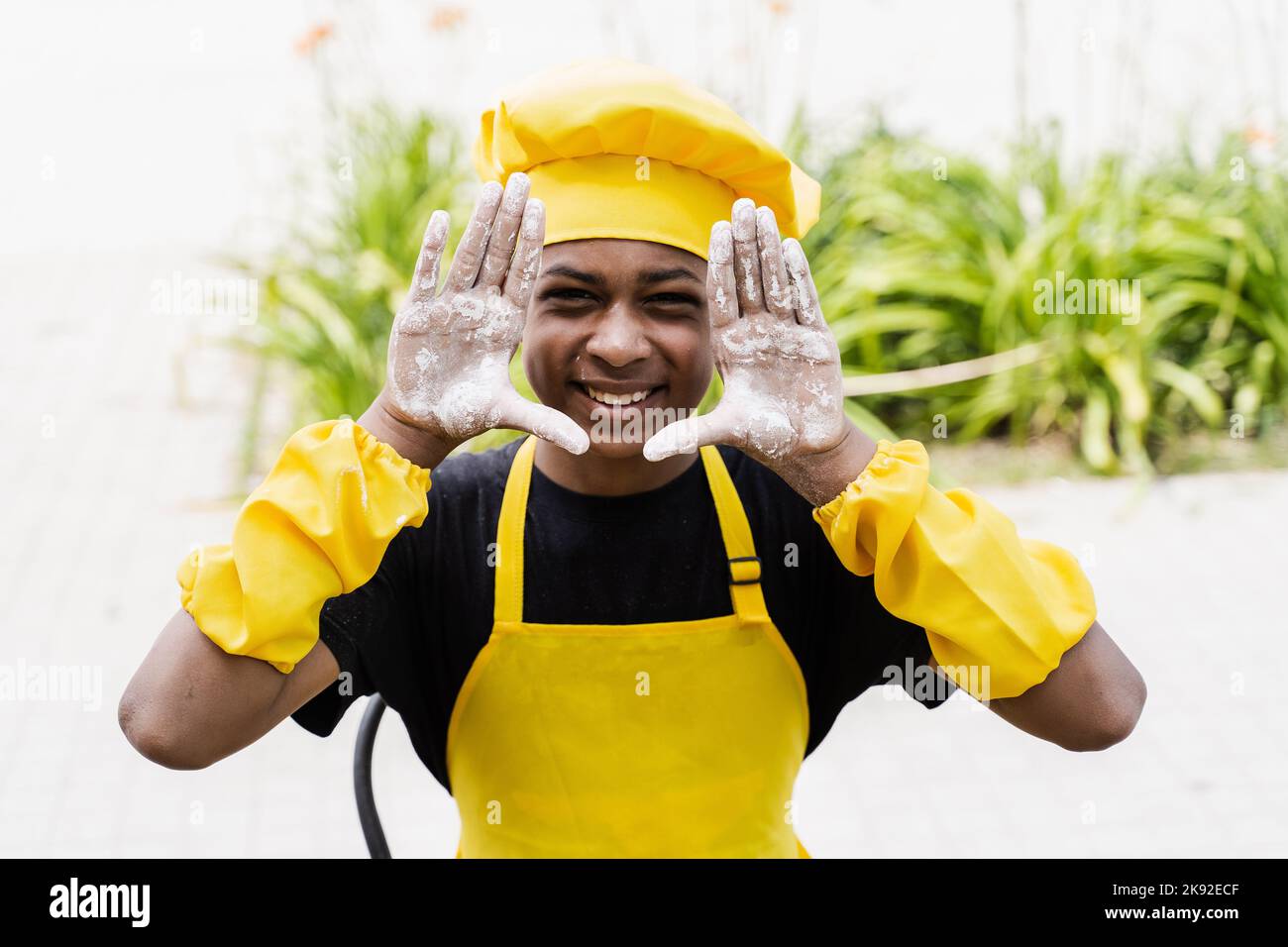 Black african cook teenager showing hands with flour and smiling ...