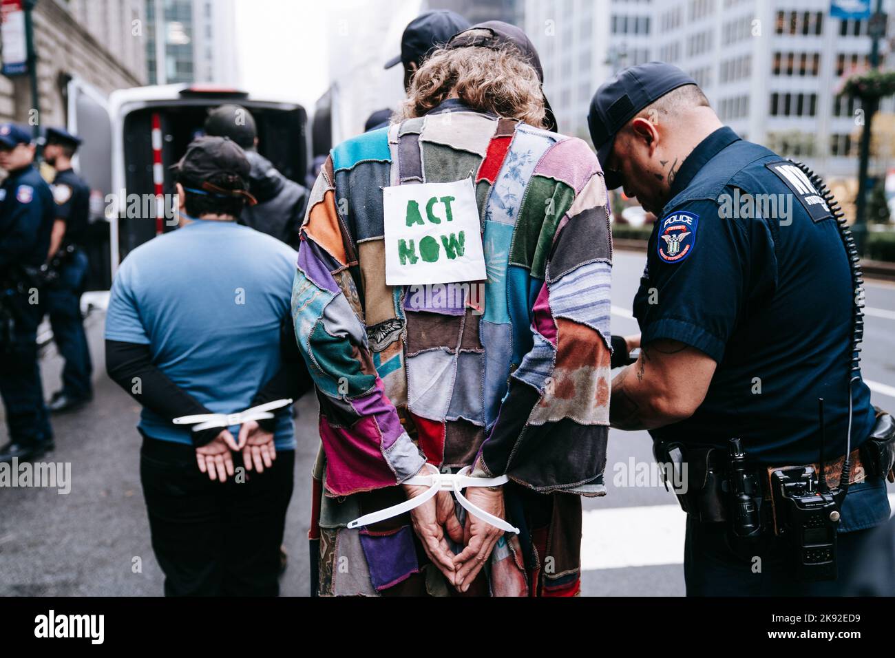 Climate activist with an "Act Now" patch on his jacket is being ...