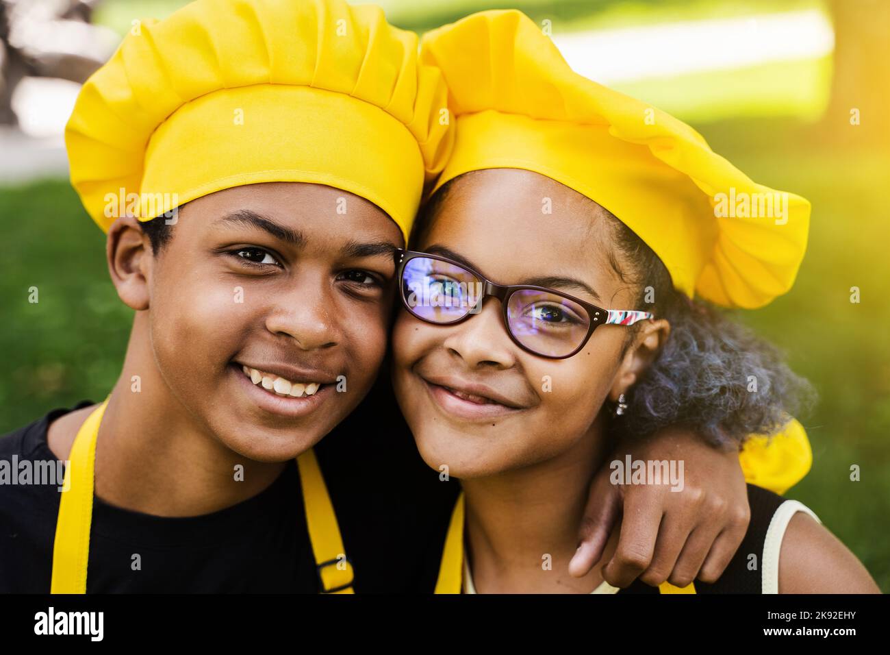 African children cooks in chefs hat and yellow uniforms smiling close ...