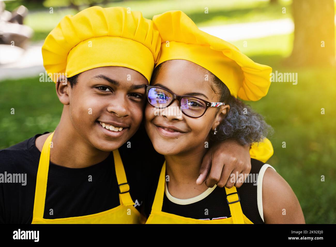African children cooks in chefs hat and yellow uniforms smiling close ...