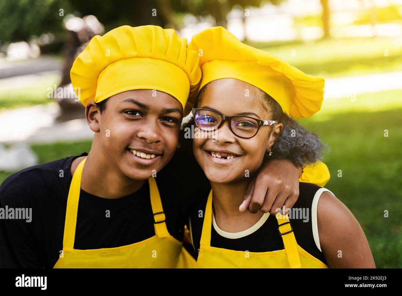 African children cooks in chefs hat and yellow uniforms smiling close ...