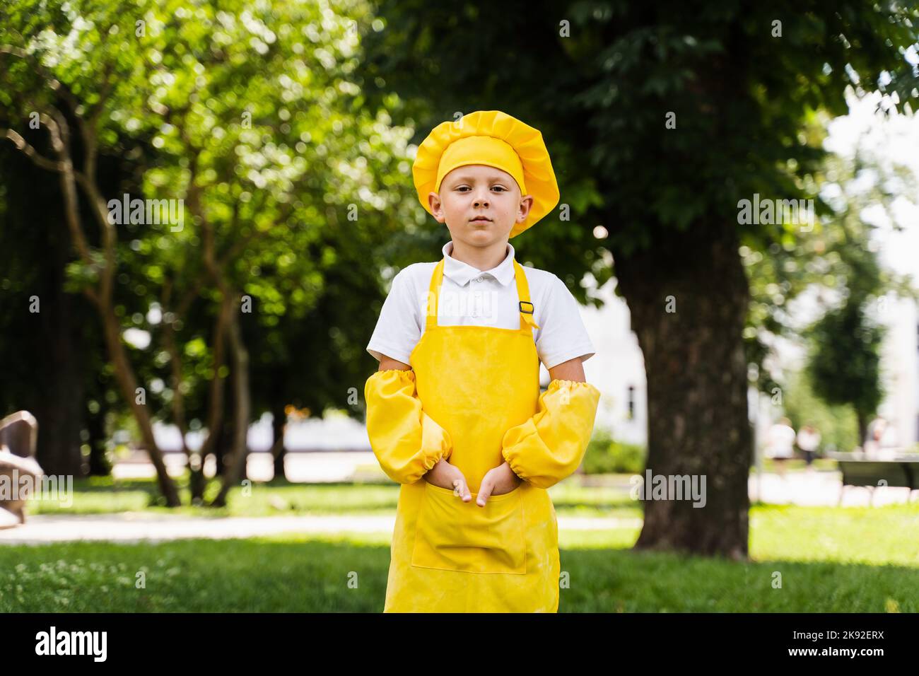 Handsome cook child in yellow chefs hat and apron yellow uniform posing ...