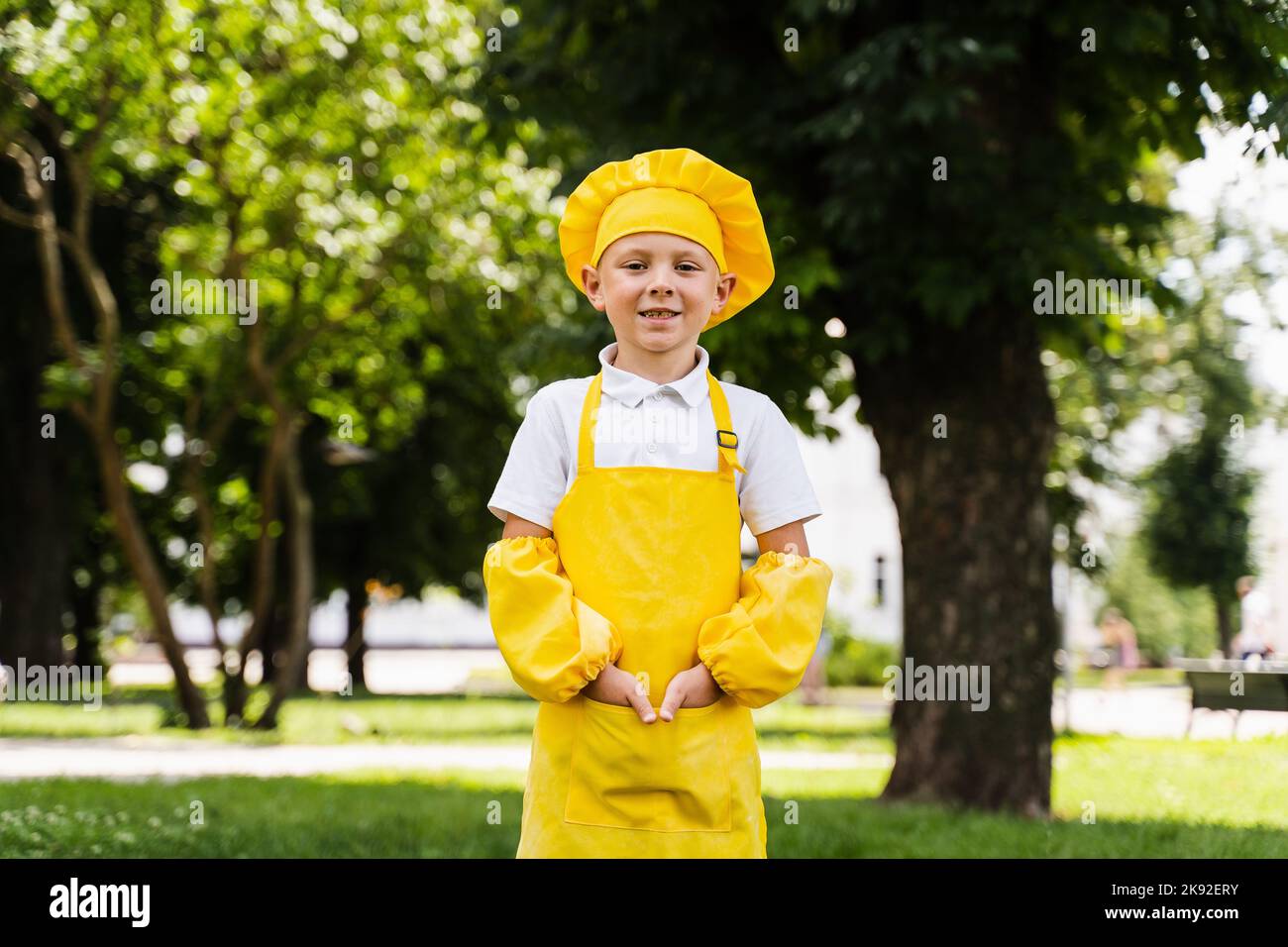 Handsome cook child in yellow chefs hat and apron yellow uniform posing ...