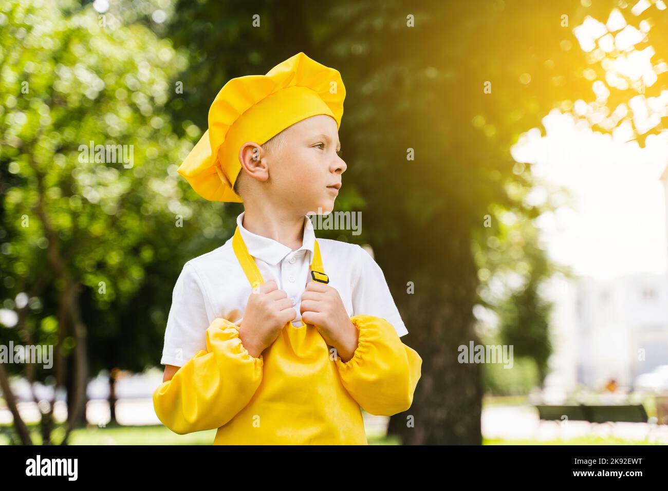 Handsome cook child in yellow chefs hat and apron yellow uniform posing ...