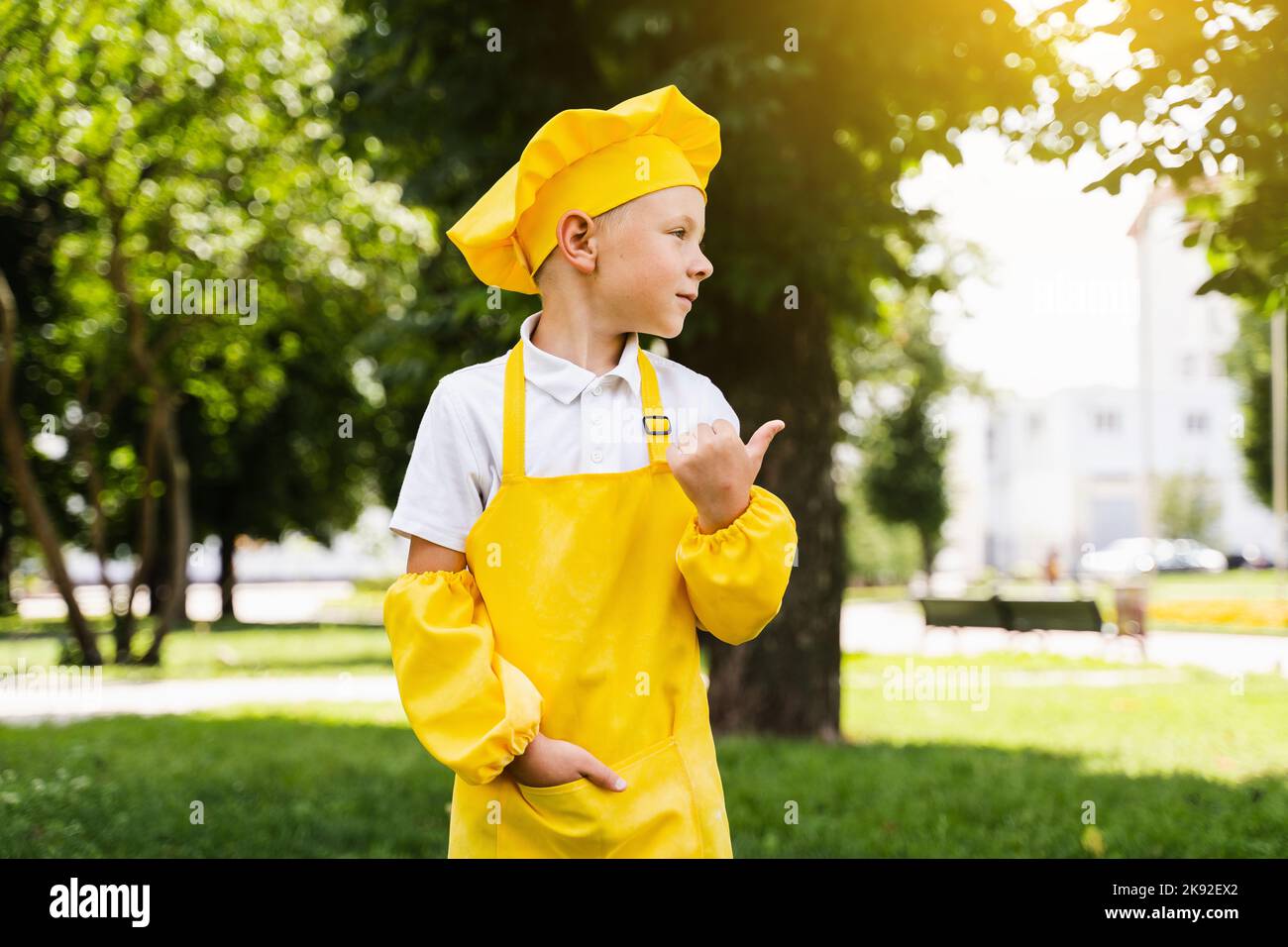 Point right. Handsome cook child in yellow chefs hat and apron yellow ...