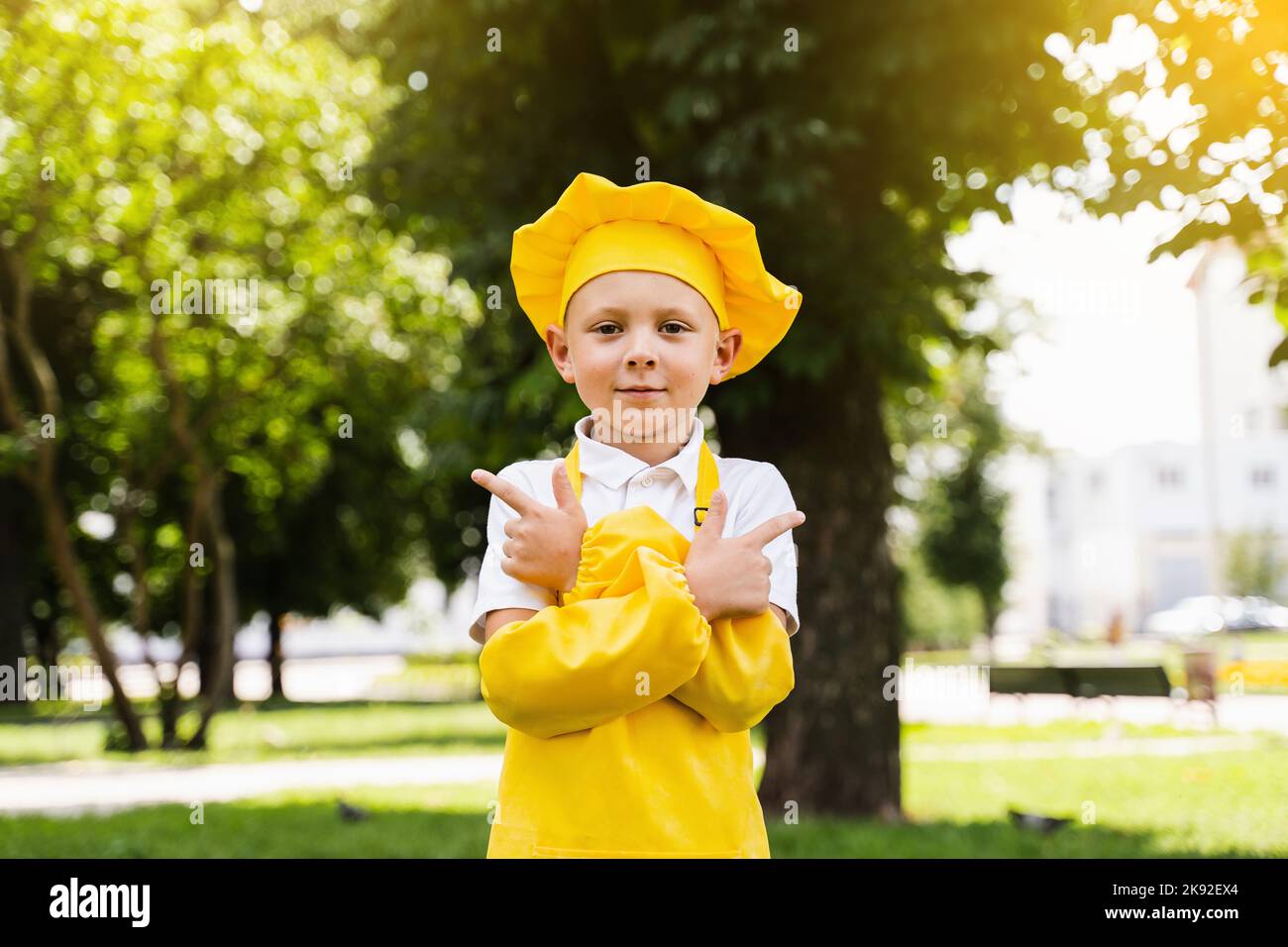 Points right. Handsome cook child in yellow chefs hat and apron yellow ...