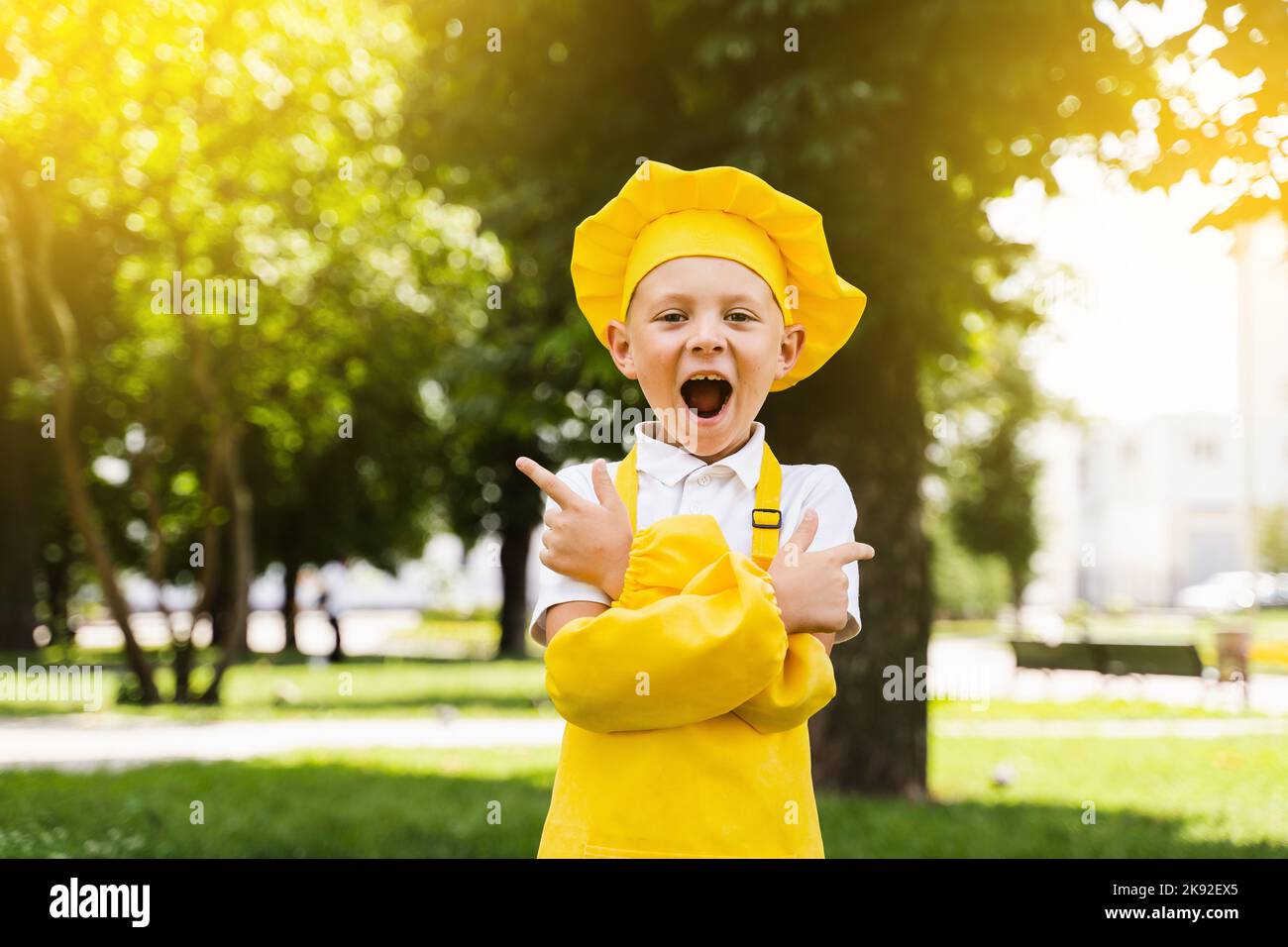 Points right. Handsome cook child in yellow chefs hat and apron yellow ...