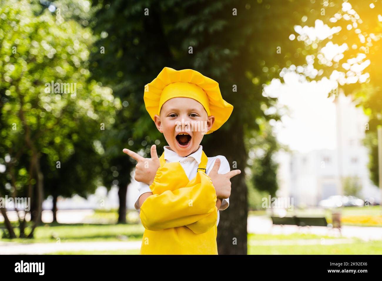 Points right. Handsome cook child in yellow chefs hat and apron yellow ...