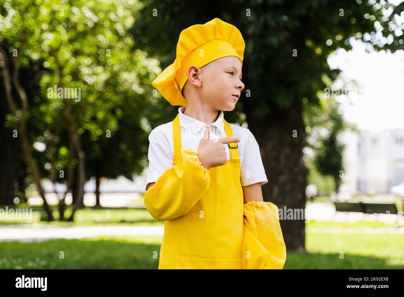 Point right. Handsome cook child in yellow chefs hat and apron yellow ...