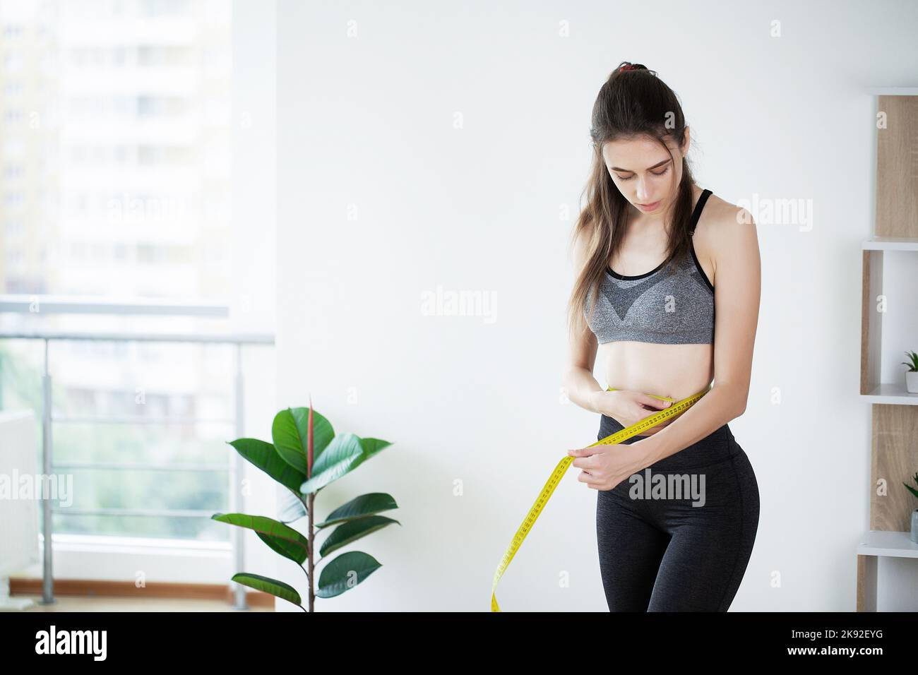 Slim young woman measuring her thin waist with a tape measure Stock ...
