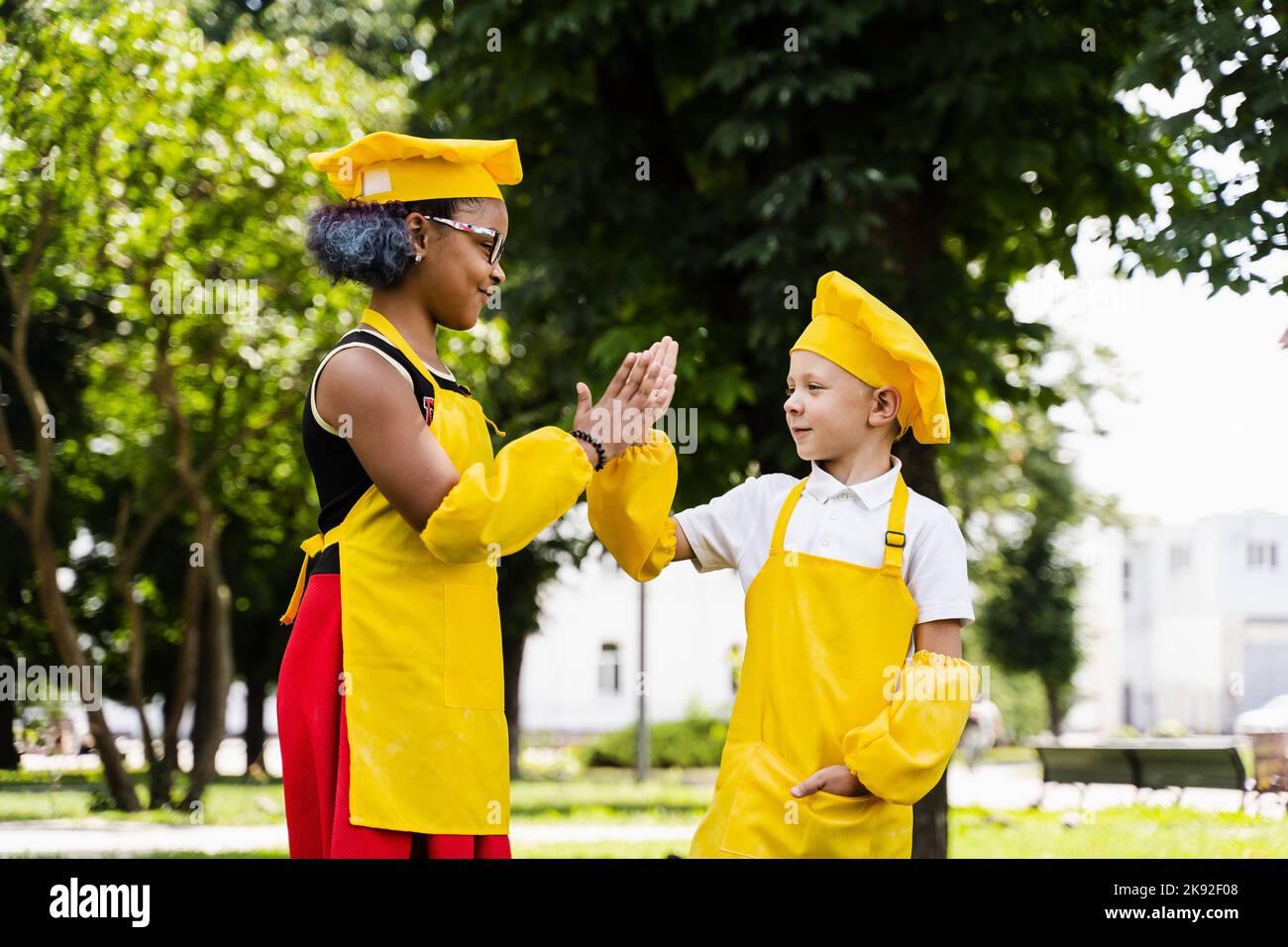 Clap hands and give five. Black african and caucasian cook child in ...