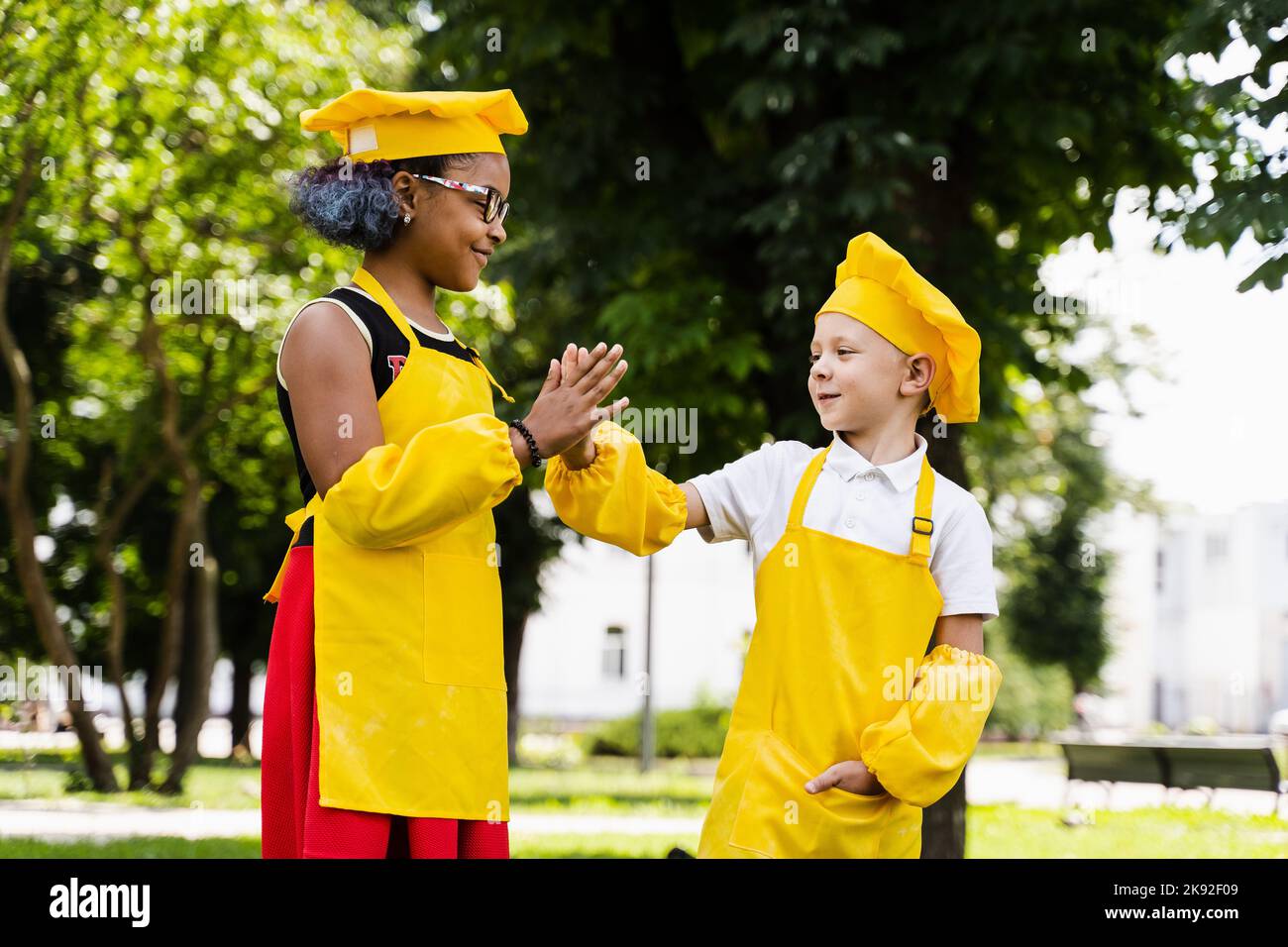 Clap hands and give five. Black african and caucasian cook child in ...