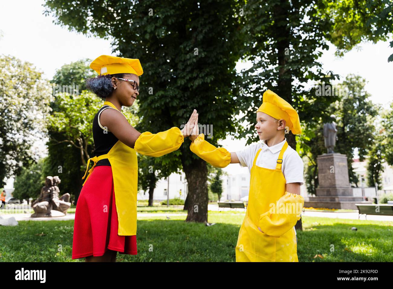 Black african and caucasian cook child in yellow chefs hat and apron ...