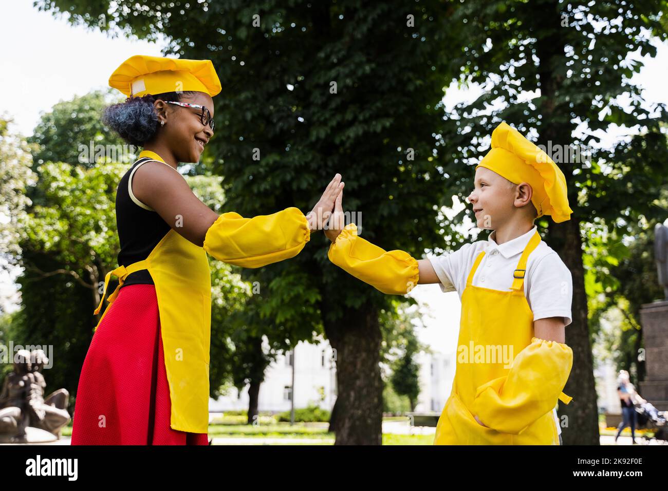 Black african and caucasian cook child in yellow chefs hat and apron ...