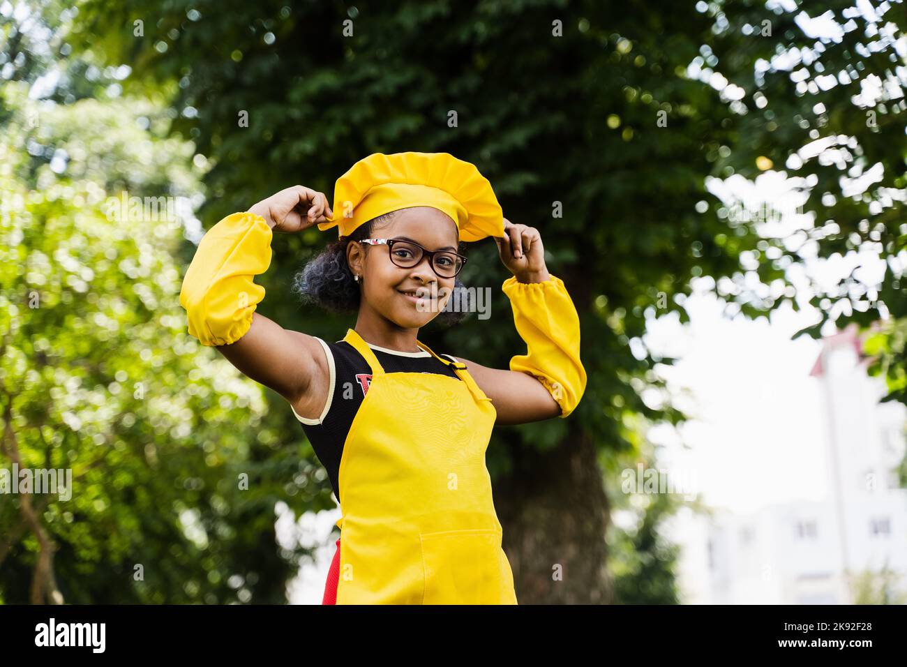 Black african child cook girl in chefs hat and yellow apron uniform ...