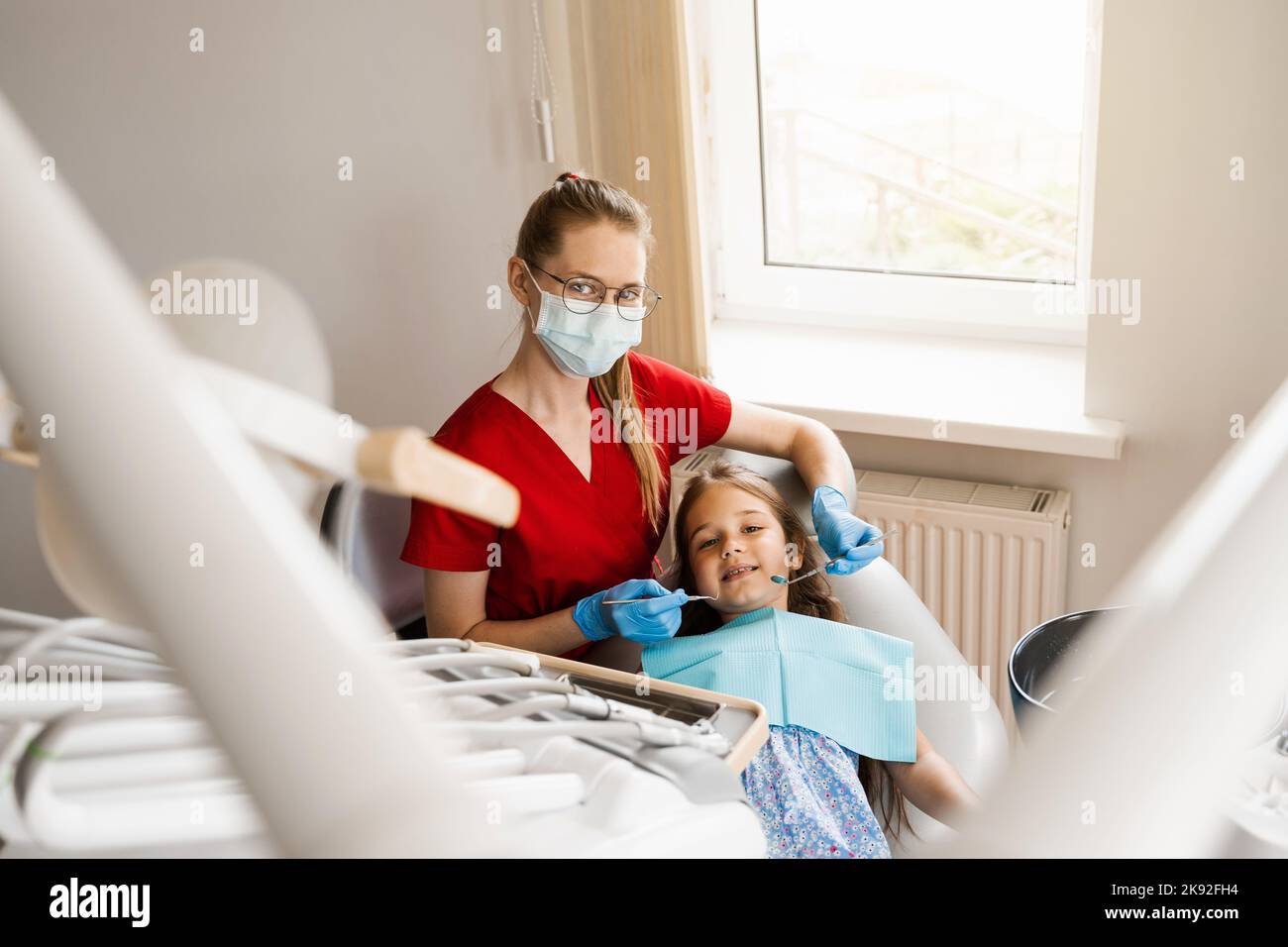 Pediatric dentist and cheerful girl child smiling in dentistry. Child ...
