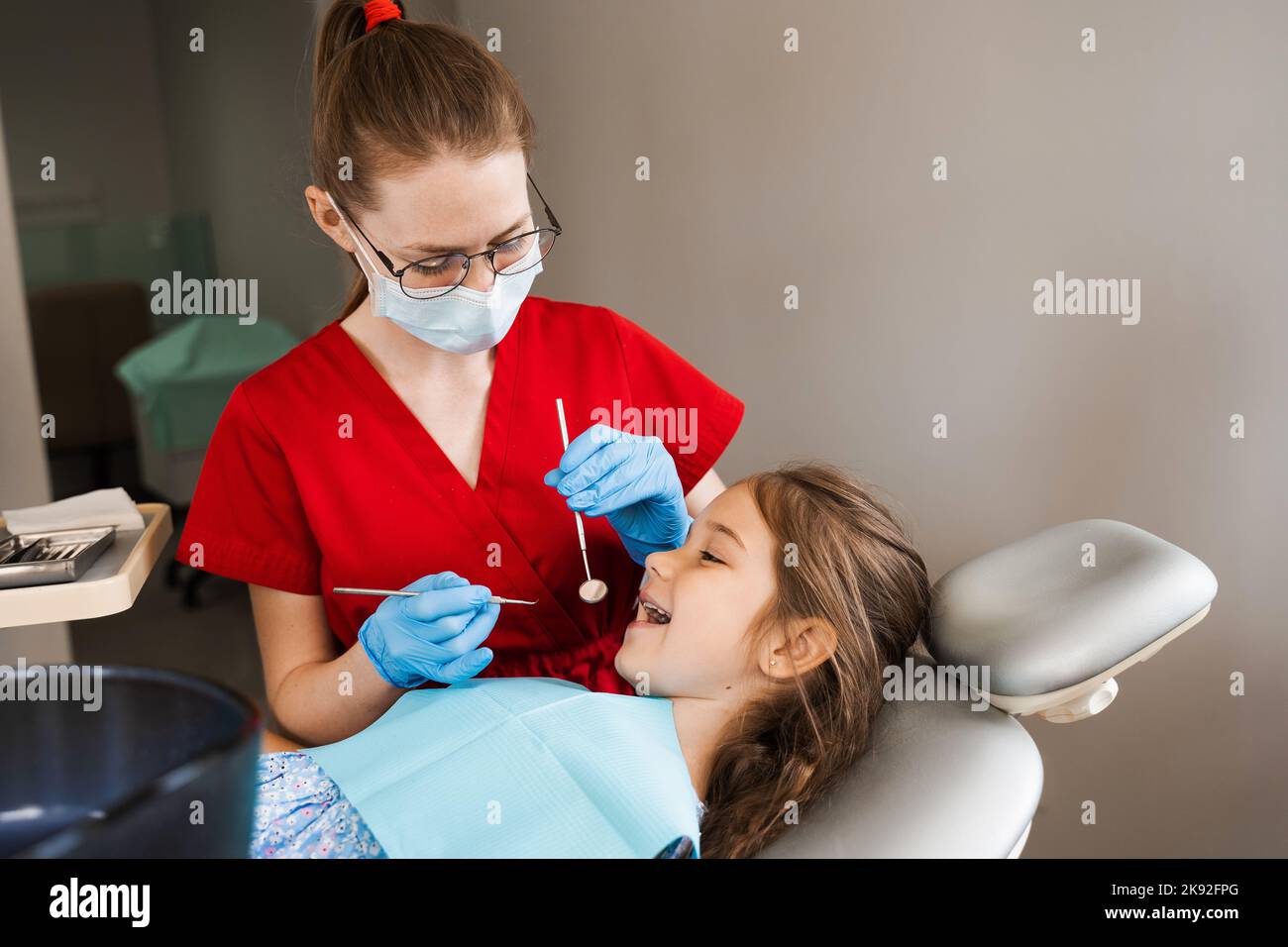 Pediatric dentist and cheerful girl child smiling in dentistry. Child ...
