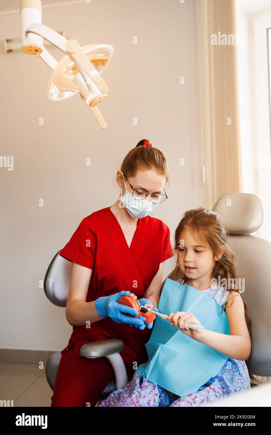 Dentist shows child how to properly use toothbrush for brush teeth. Jaw ...