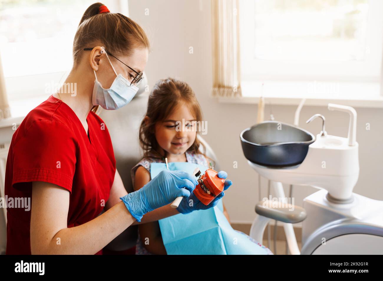 Dentist shows child how to properly use toothbrush for brush teeth. Jaw ...