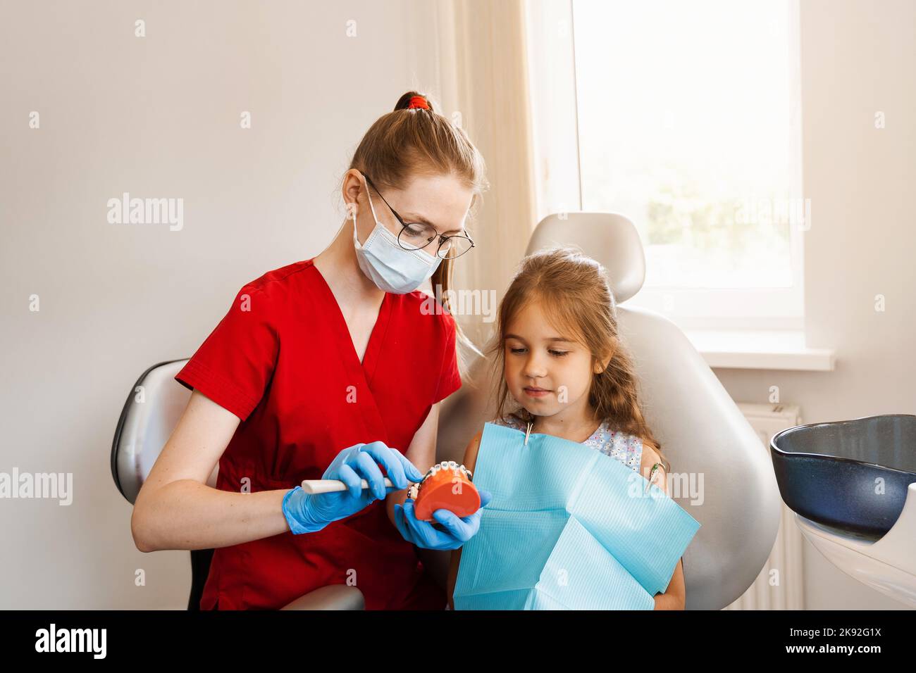 Dentist shows child how to properly use toothbrush for brush teeth. Jaw ...