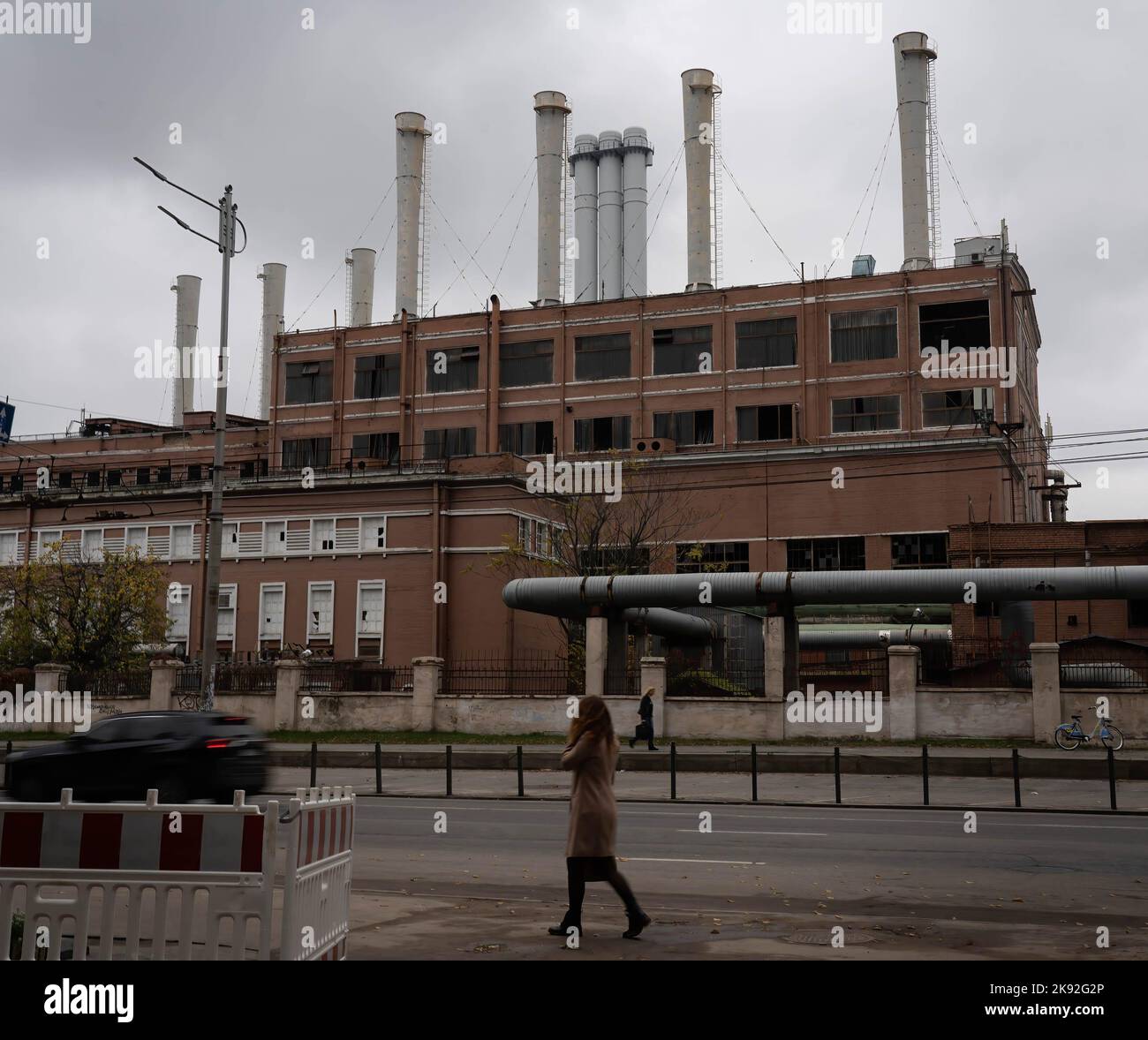 A woman walks past an electric utility infrastructure in Kyiv. Ukraine ...