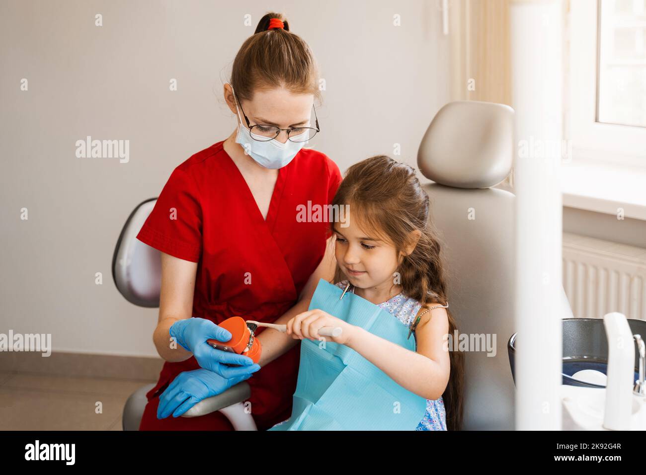 Pediatric dentist teaching oral hygiene lesson for kids in dentistry ...