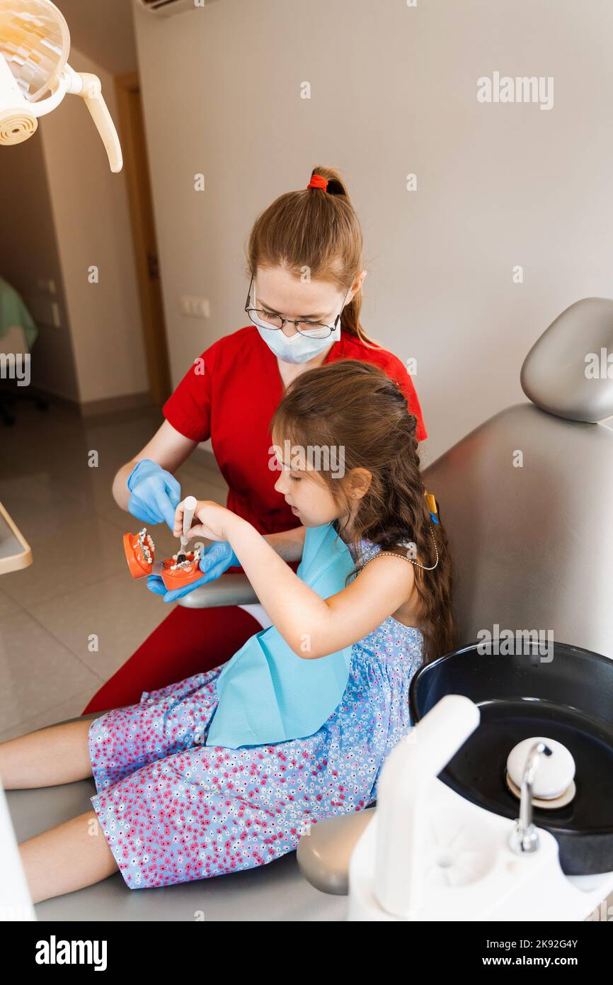 Dentist shows child how to properly use toothbrush for brush teeth. Jaw ...
