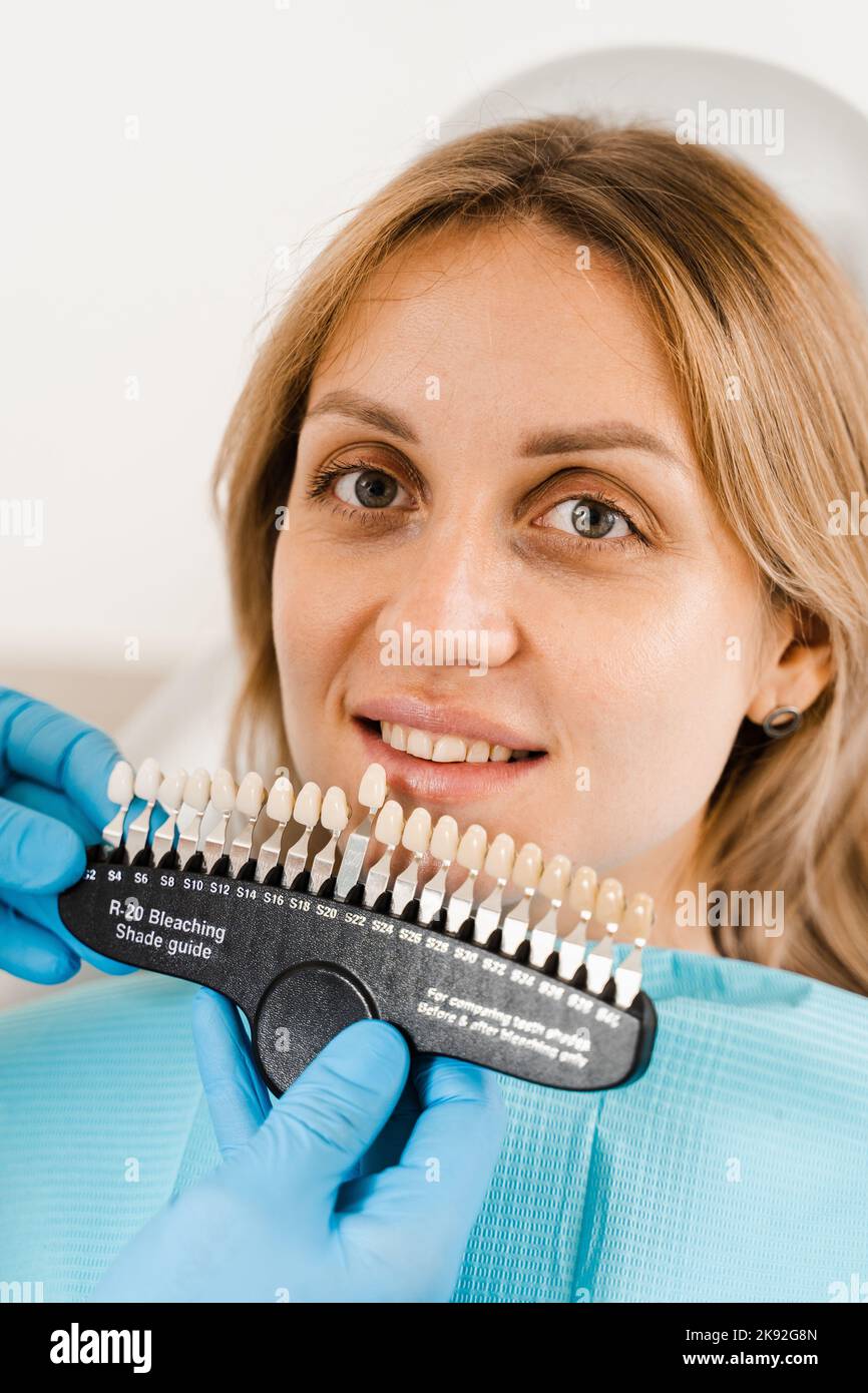Teeth color shades guide with woman patient. Tooth whitening. Dentist ...