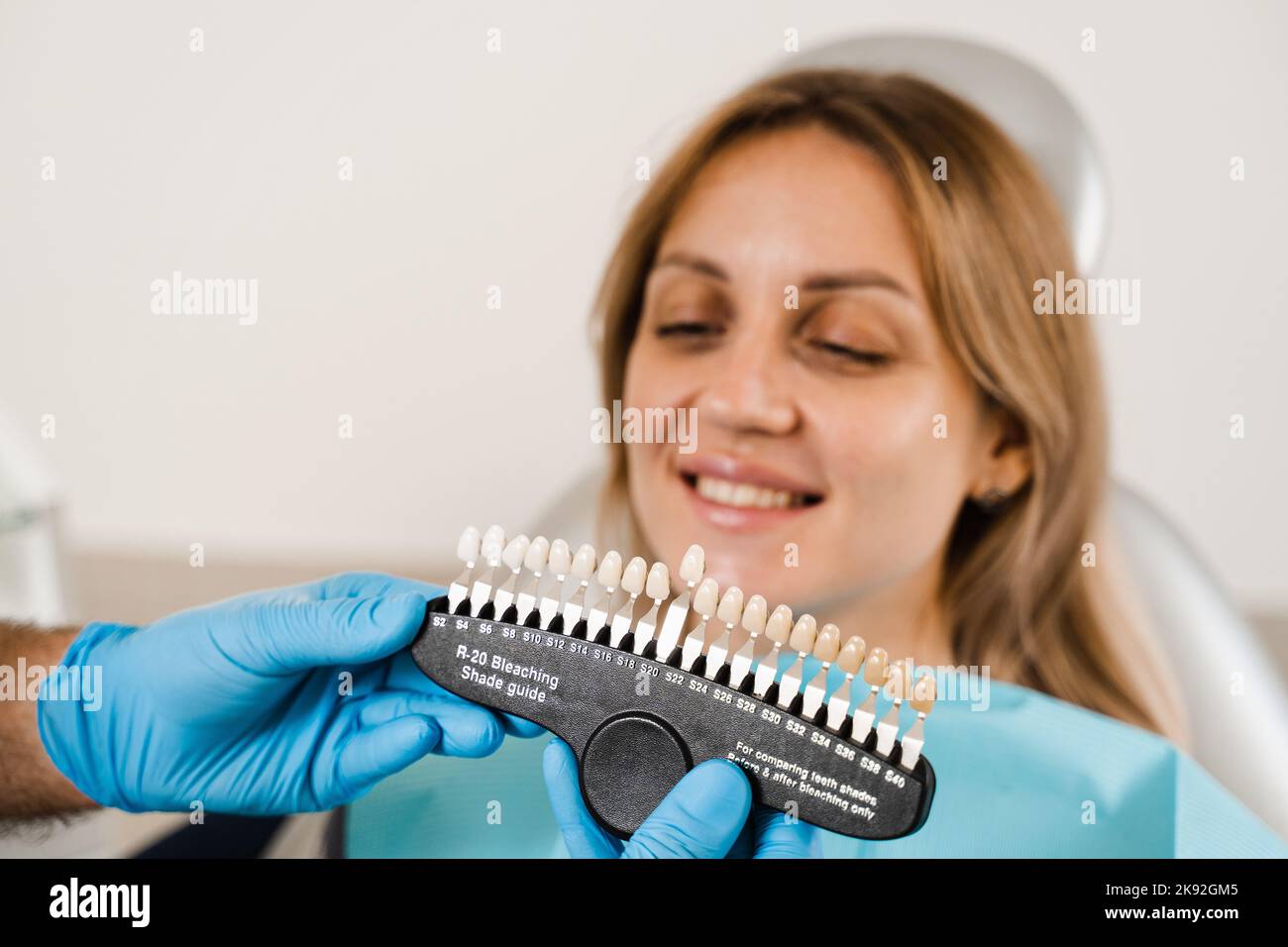 Teeth color shades guide with woman patient. Tooth whitening. Dentist ...