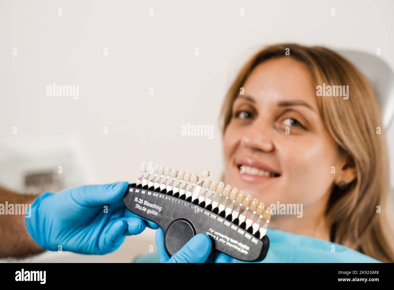 Teeth color shades guide with woman patient. Tooth whitening. Dentist ...