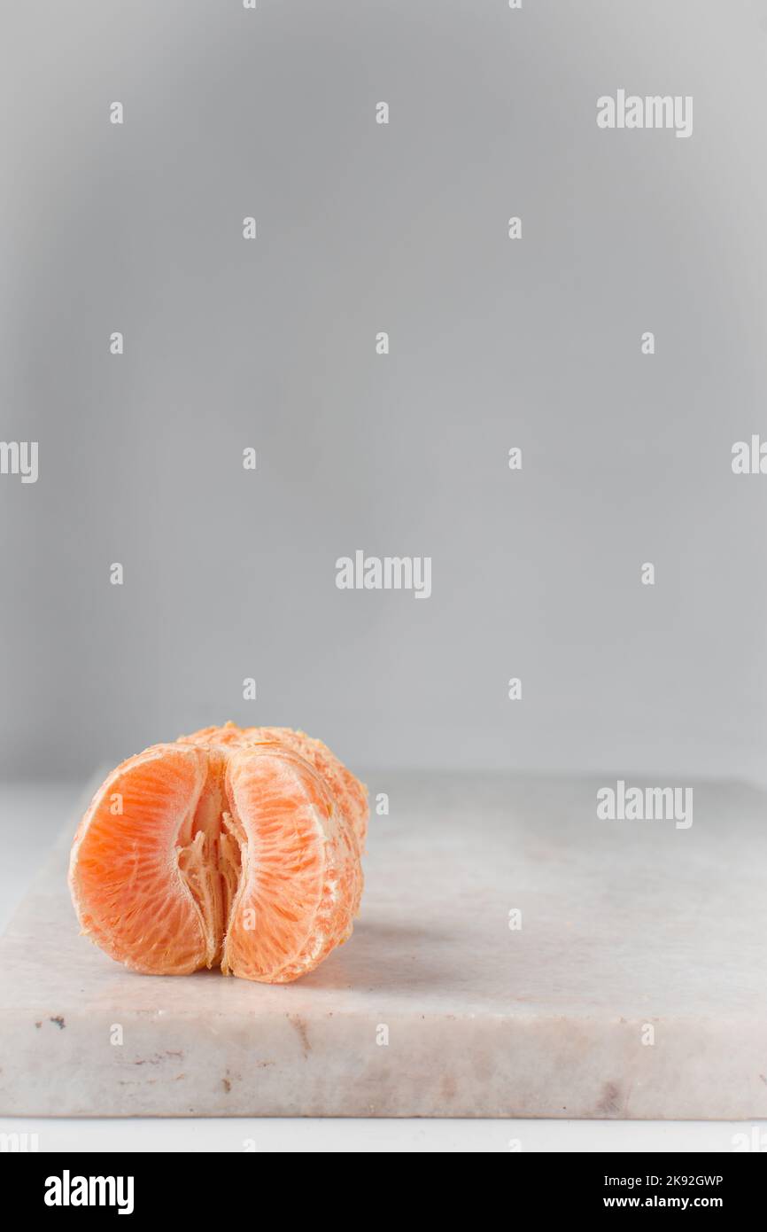Peeled clementines on a marble chopping board, orange clementines ...