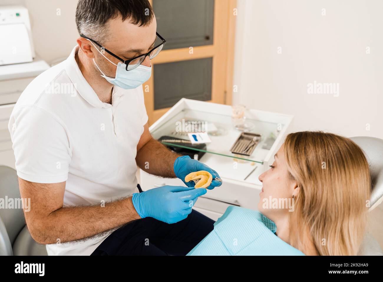 Dentist showing cast of teeth of patient woman before dental ...