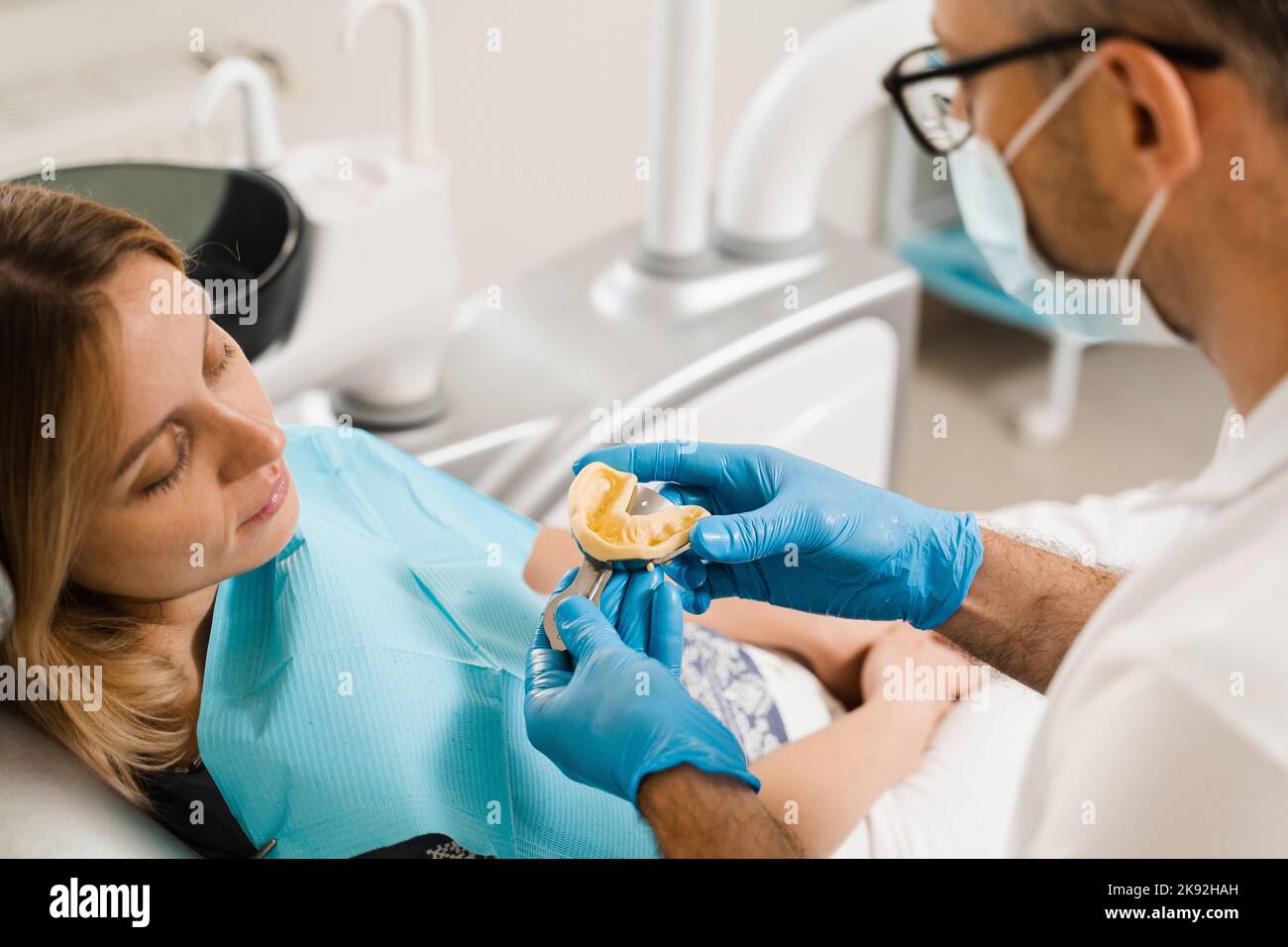 Dentist showing cast of teeth of patient woman before dental ...