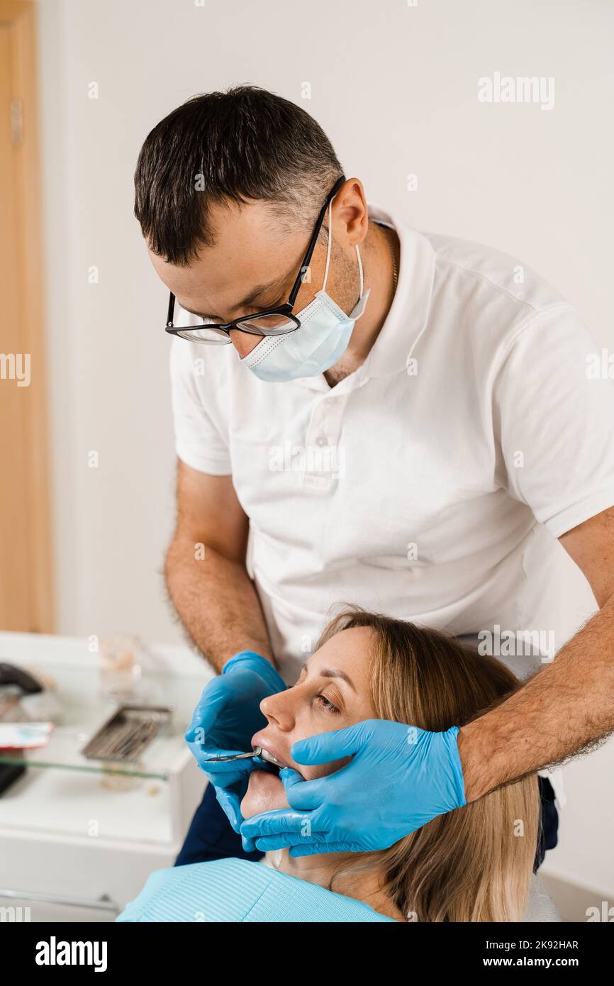 Doctor inserts impression tray and making cast of teeth to patient in ...