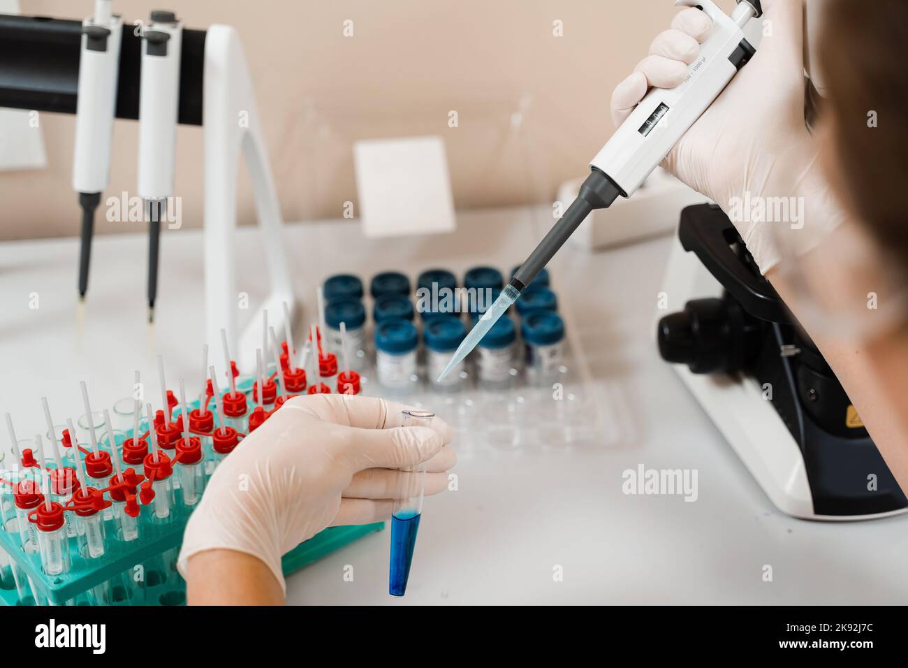 Laboratory assistant with microdoser in laboratory doing blood test ...