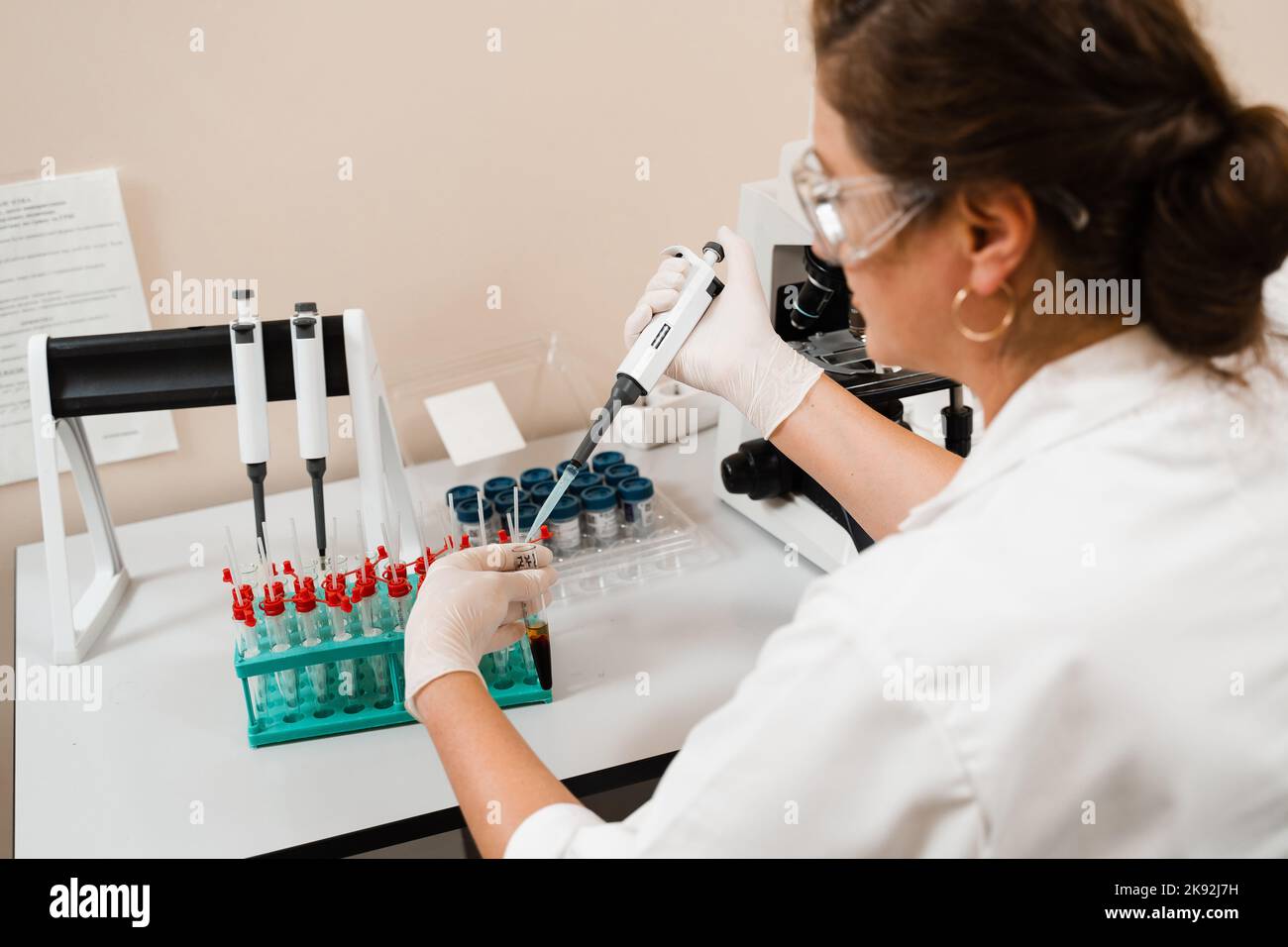 Laboratory assistant with microdoser in laboratory doing blood test ...