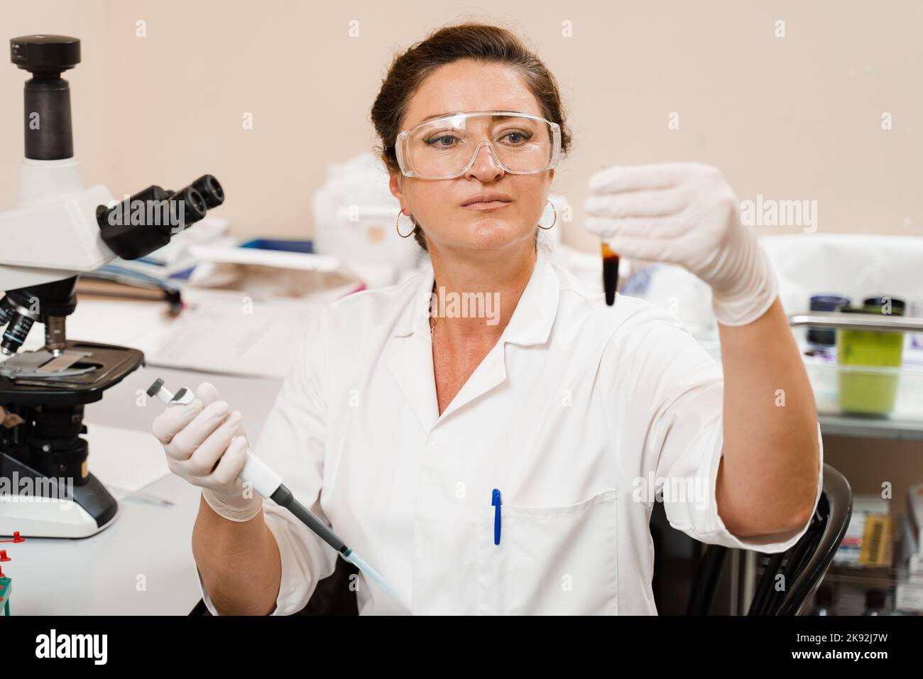 Laboratory assistant with microdoser in laboratory doing blood test ...